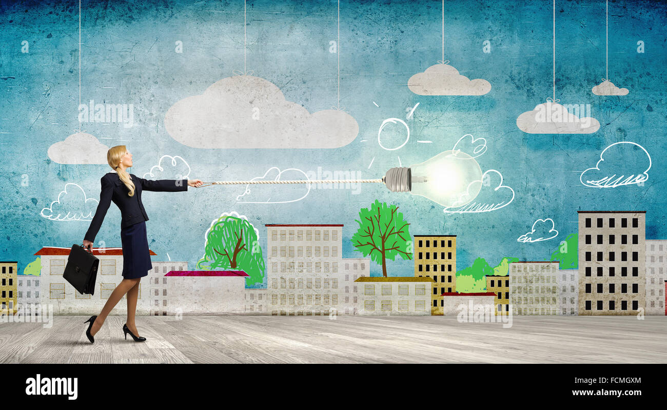 Young businesswoman pulling light bulb on rope Stock Photo - Alamy