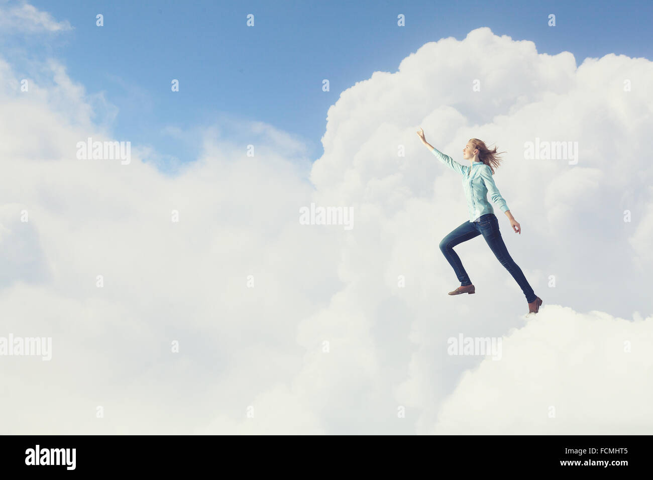 Young woman high in sky reaching up Stock Photo - Alamy