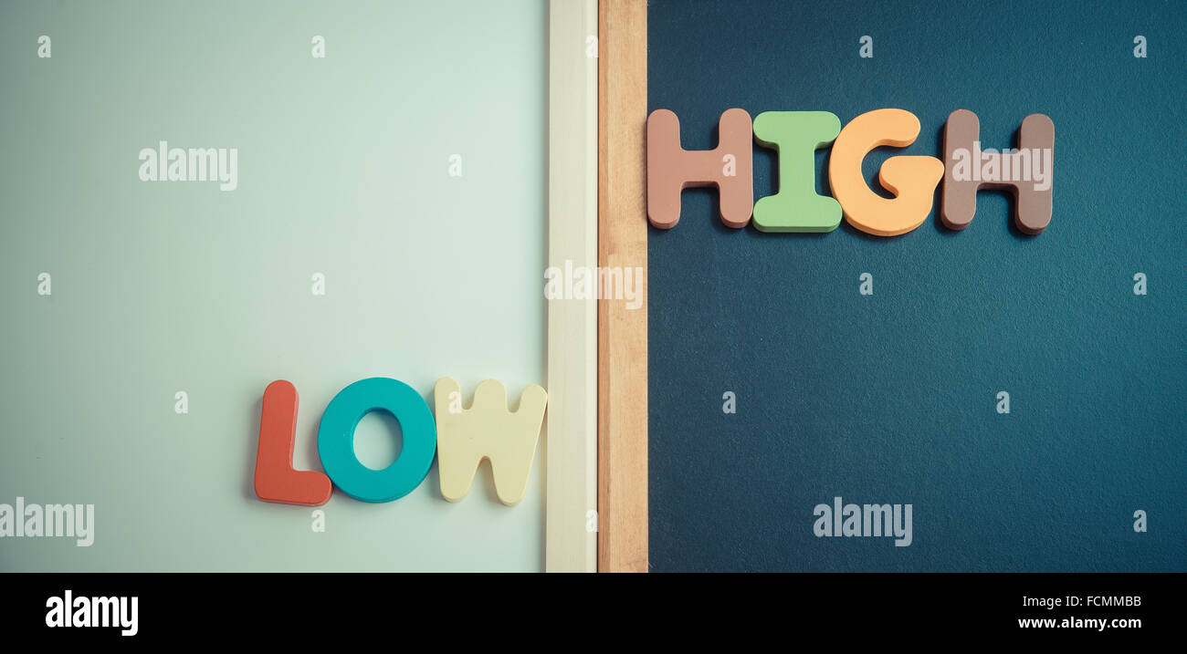 Wooden word LOW and HIGH on black board and white board in Vintage ...
