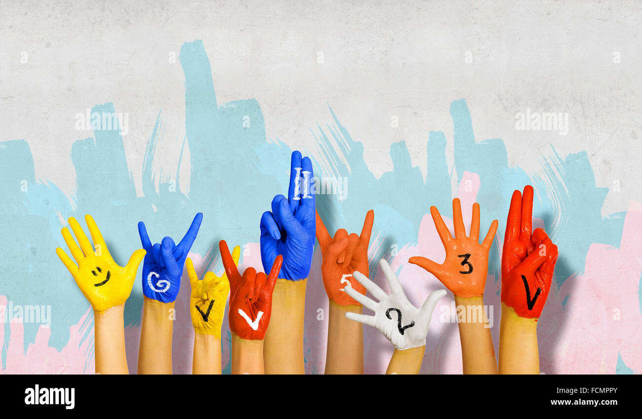 Human hands in colorful paint showing symbols Stock Photo - Alamy