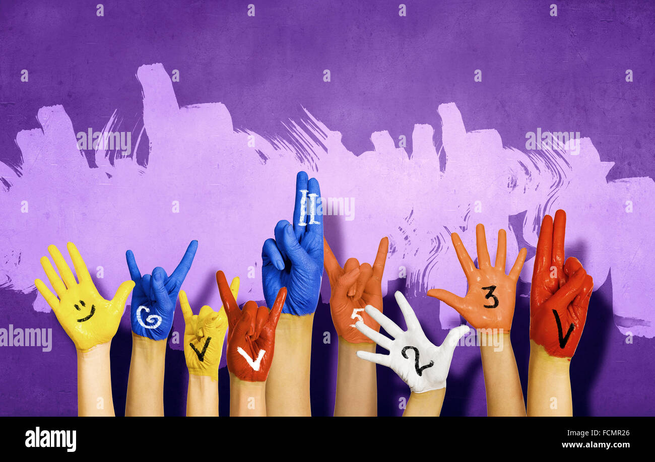 Human hands in colorful paint showing symbols Stock Photo - Alamy