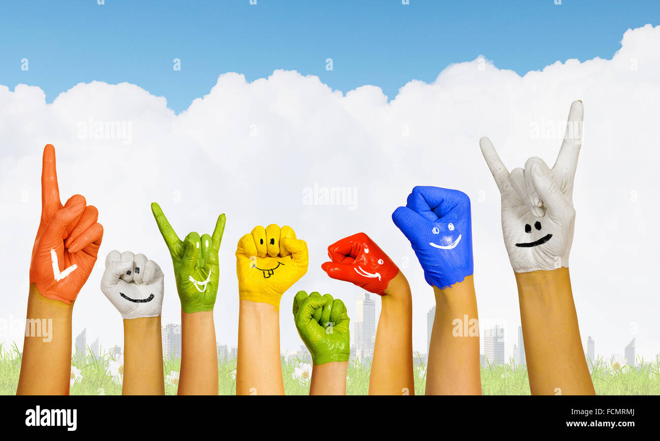Human hands in colorful paint showing symbols Stock Photo - Alamy