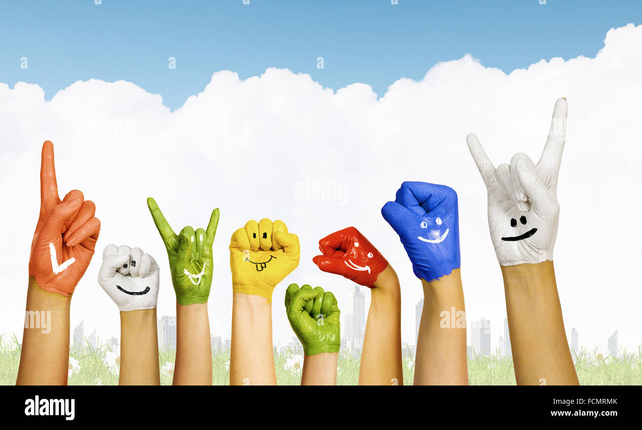 Human hands in colorful paint showing symbols Stock Photo - Alamy
