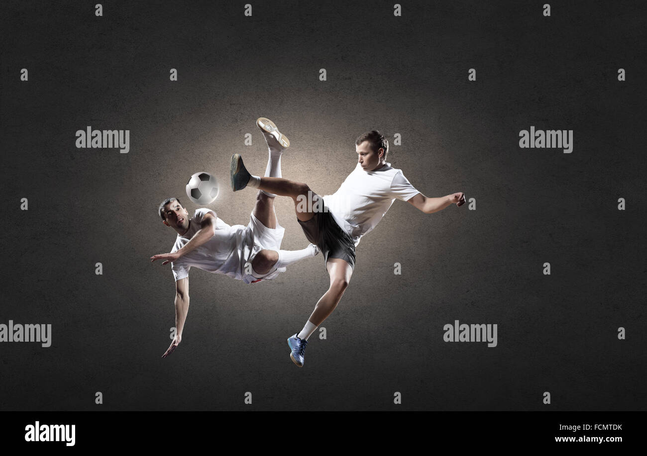 Two football players in jump fighting for ball Stock Photo - Alamy