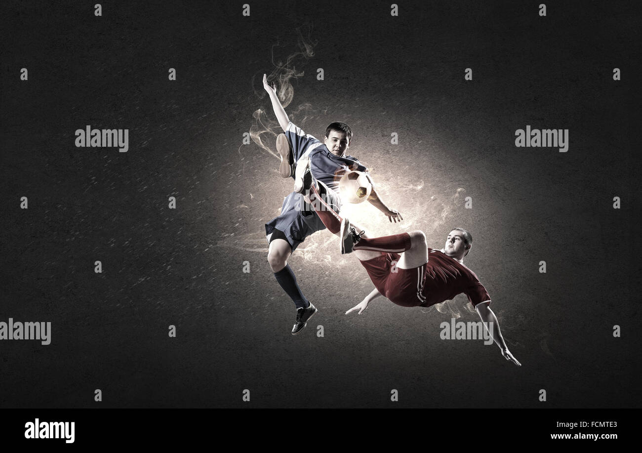 Two football players in jump fighting for ball Stock Photo - Alamy