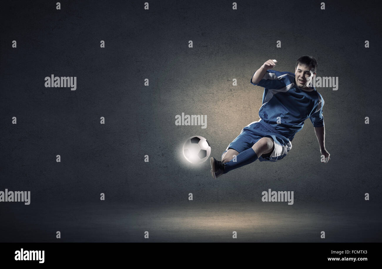 Football player in high jump taking ball Stock Photo - Alamy
