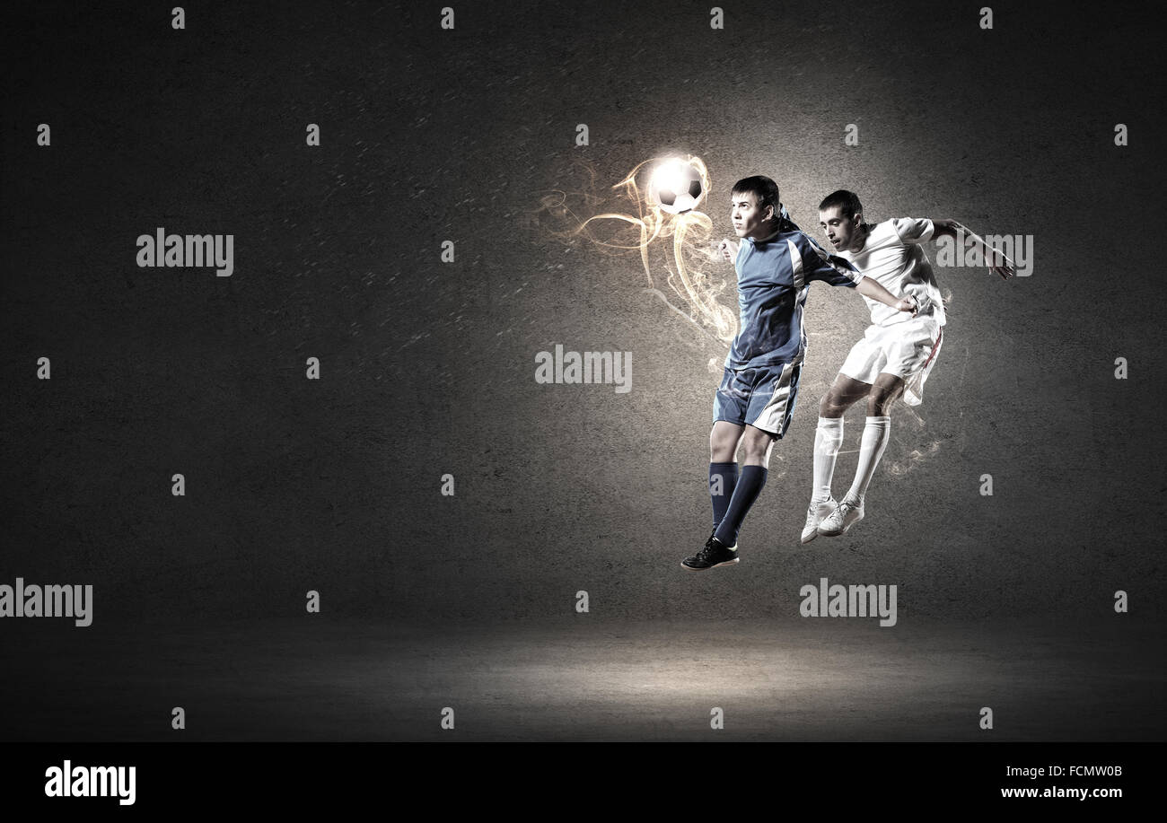 Two football players in jump fighting for ball Stock Photo - Alamy