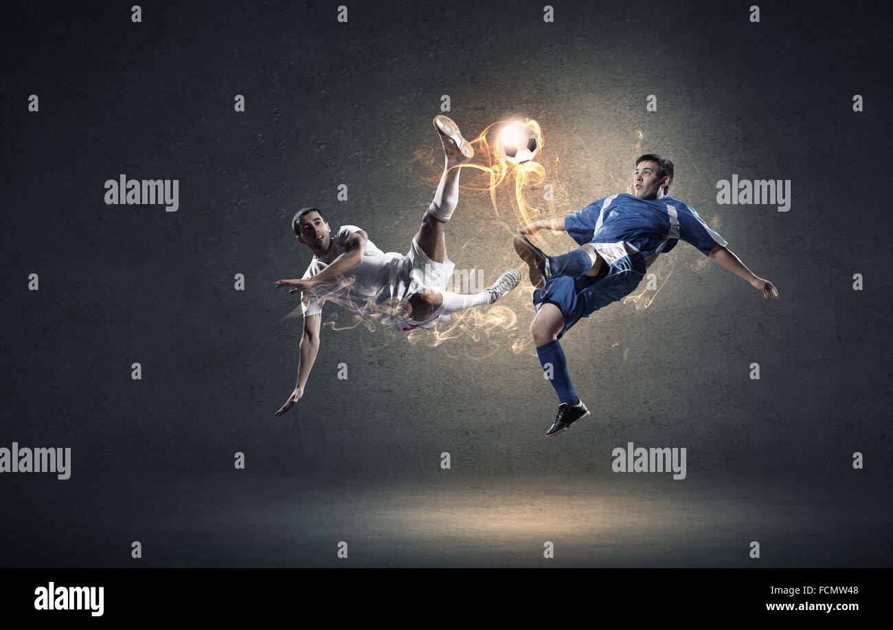 Two football players in jump fighting for ball Stock Photo - Alamy
