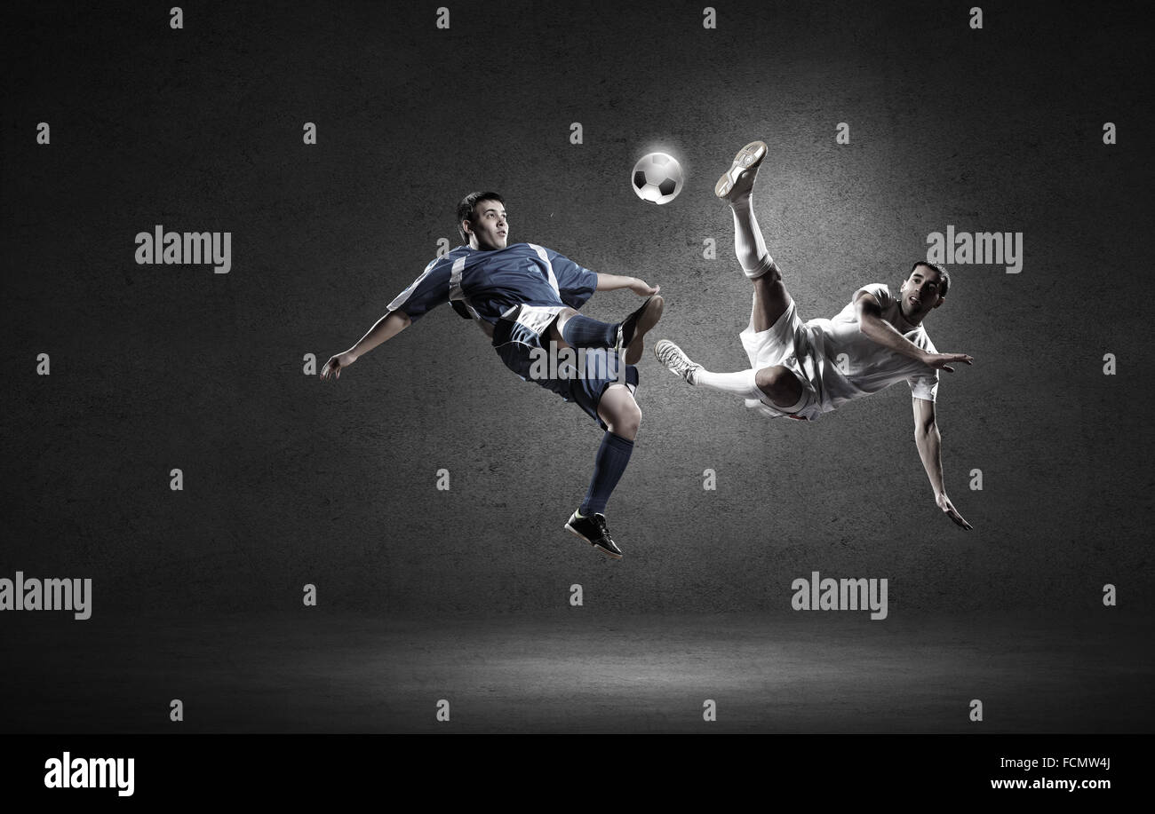 Two football players in jump fighting for ball Stock Photo - Alamy