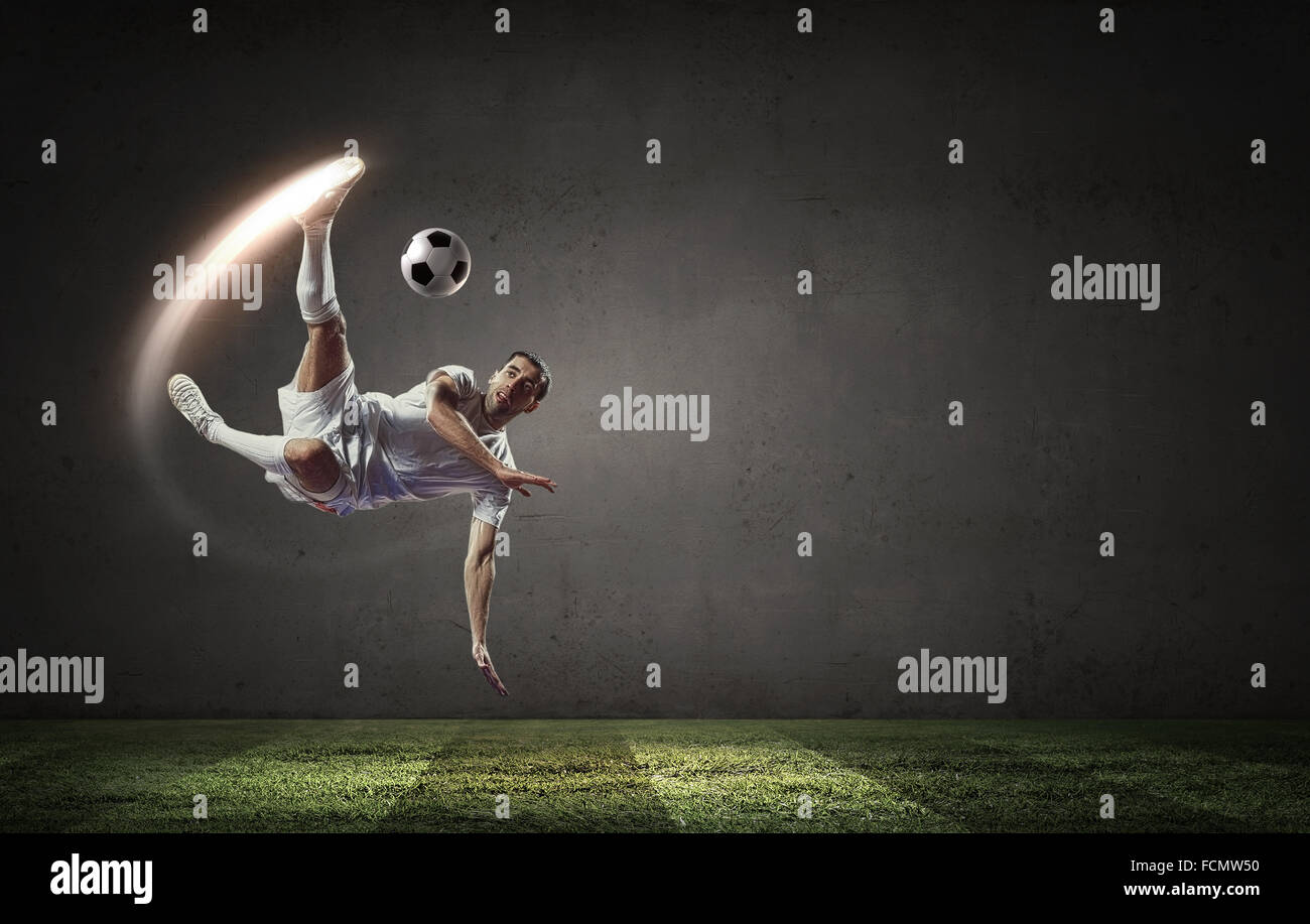 Football player in high jump taking ball Stock Photo - Alamy