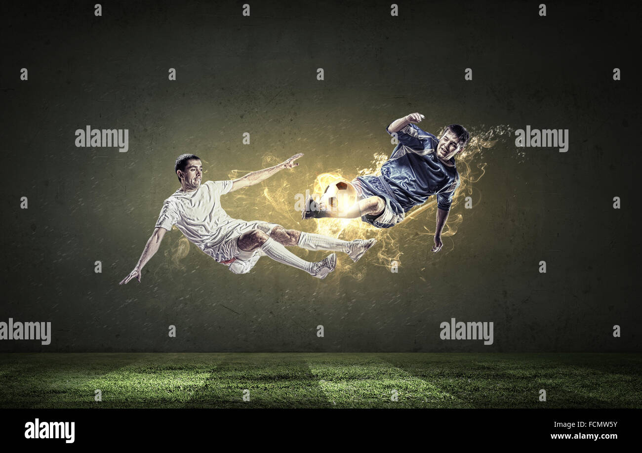 Two football players in jump fighting for ball Stock Photo - Alamy