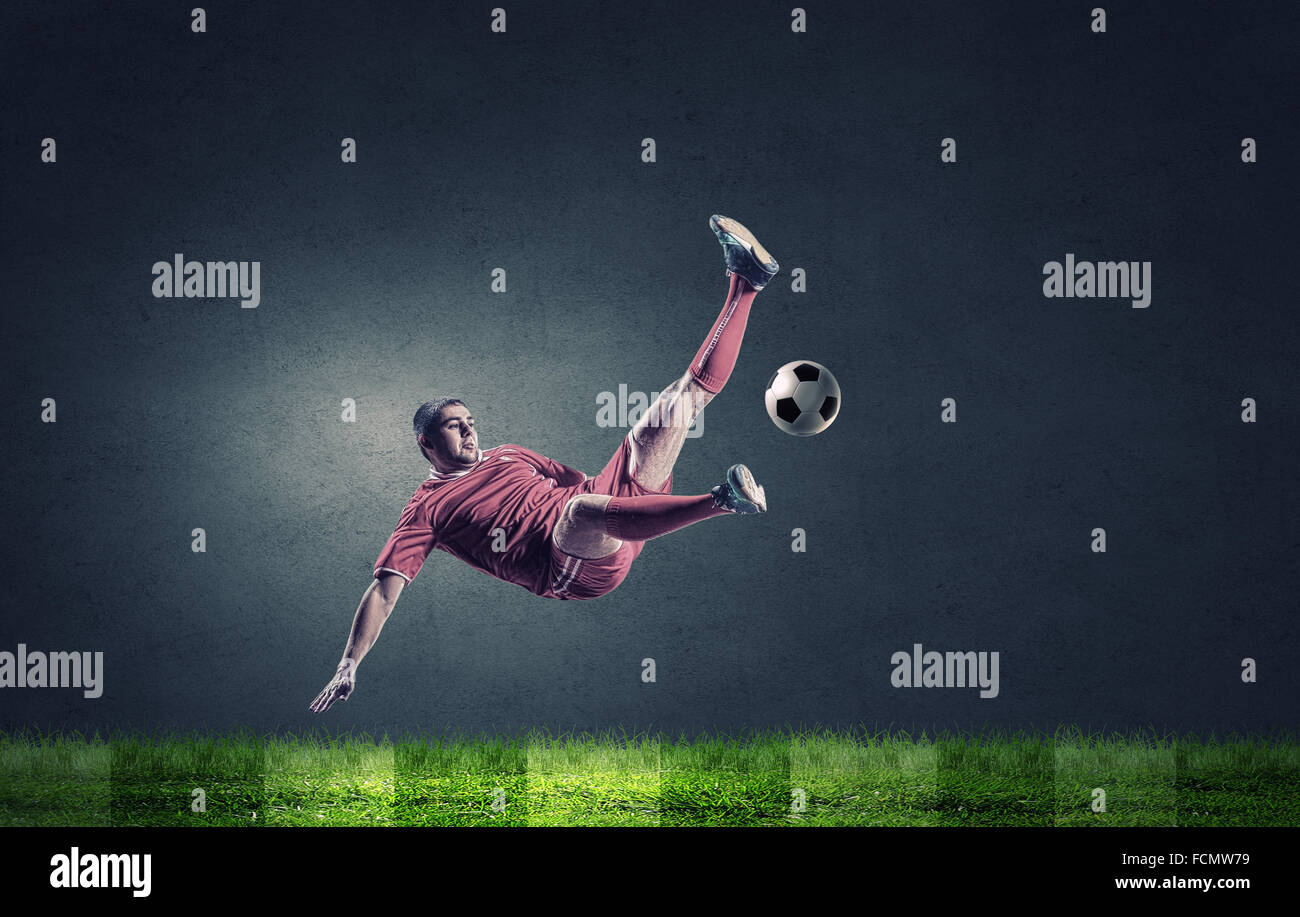 Football player in red shirt jump taking ball Stock Photo - Alamy