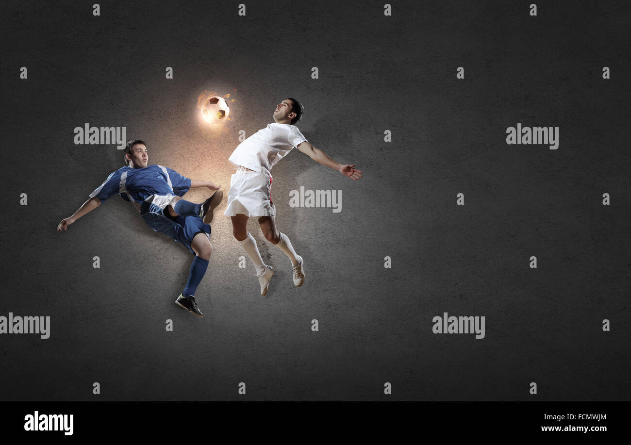 Two football players in jump fighting for ball Stock Photo - Alamy