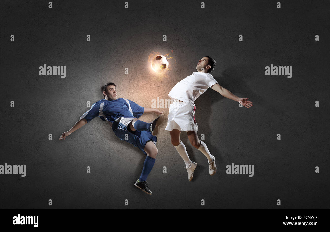 Two football players in jump fighting for ball Stock Photo - Alamy