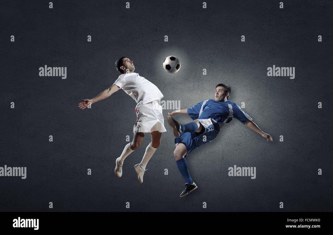 Two football players in jump fighting for ball Stock Photo - Alamy