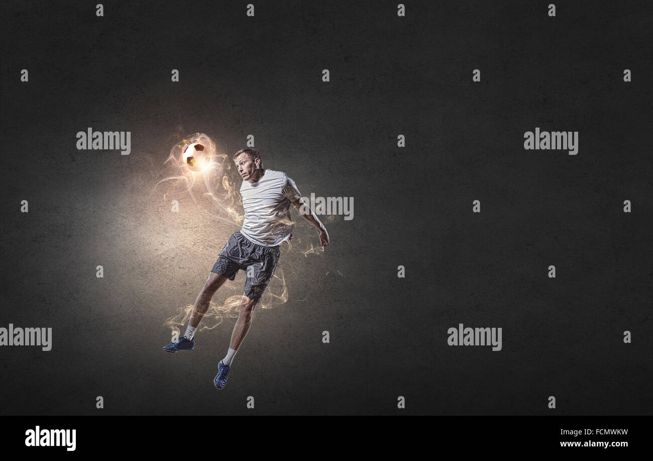 Football player in high jump taking ball Stock Photo - Alamy