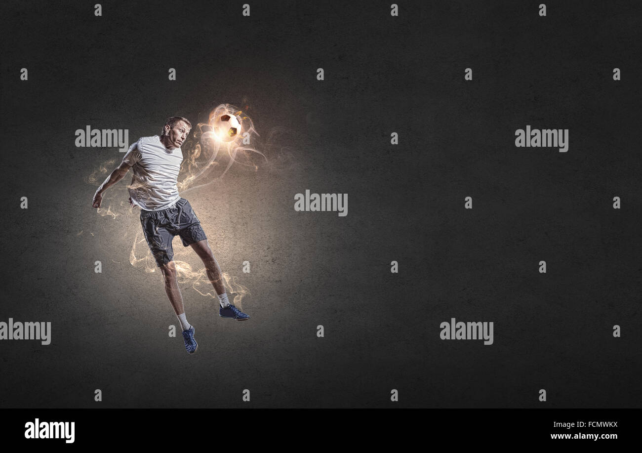 Football player in high jump taking ball Stock Photo - Alamy
