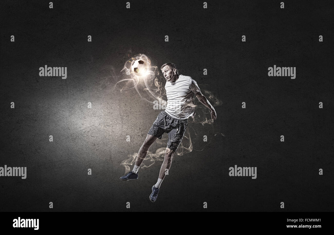 Football player in high jump taking ball Stock Photo - Alamy