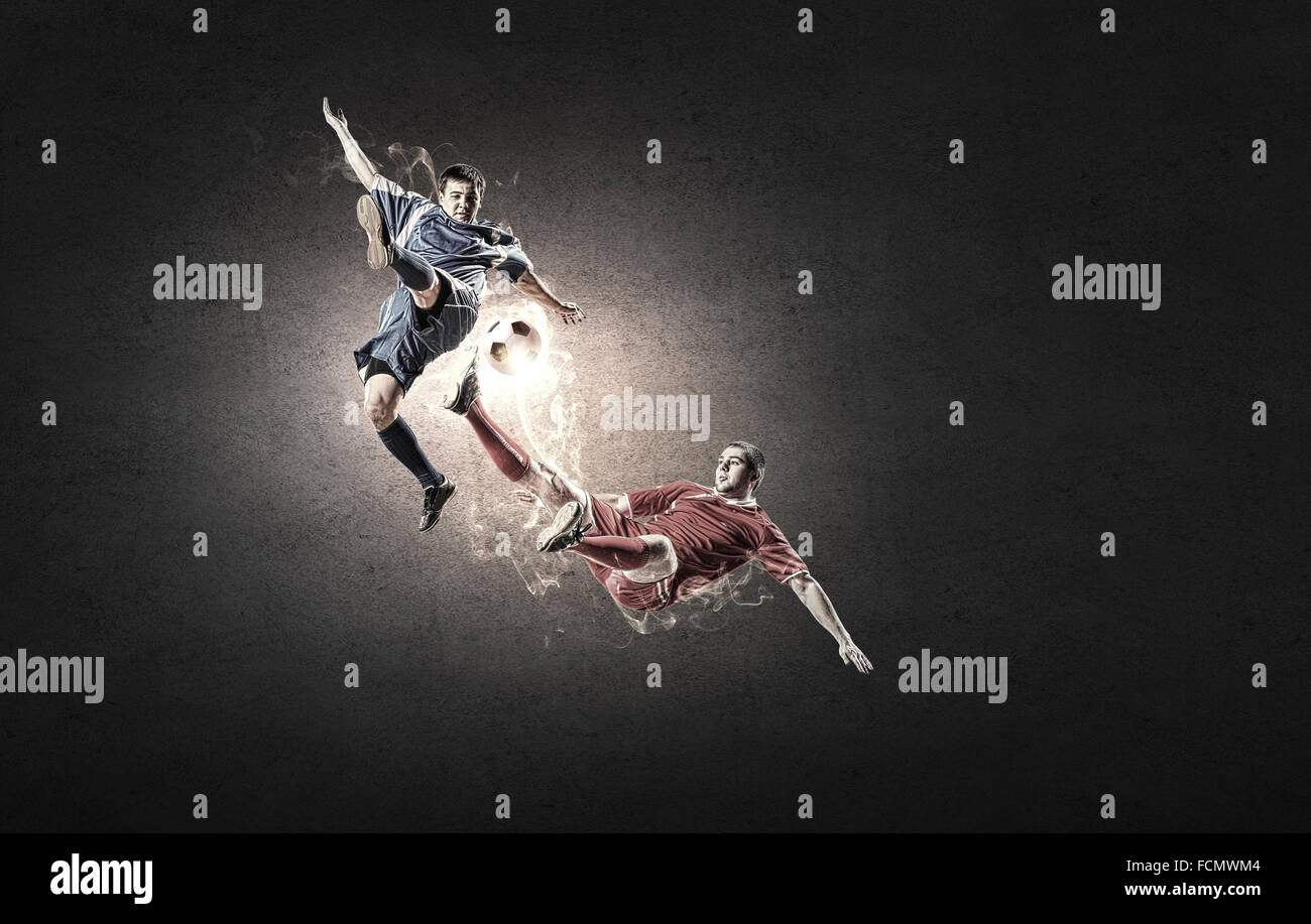 Two football players in jump fighting for ball Stock Photo - Alamy