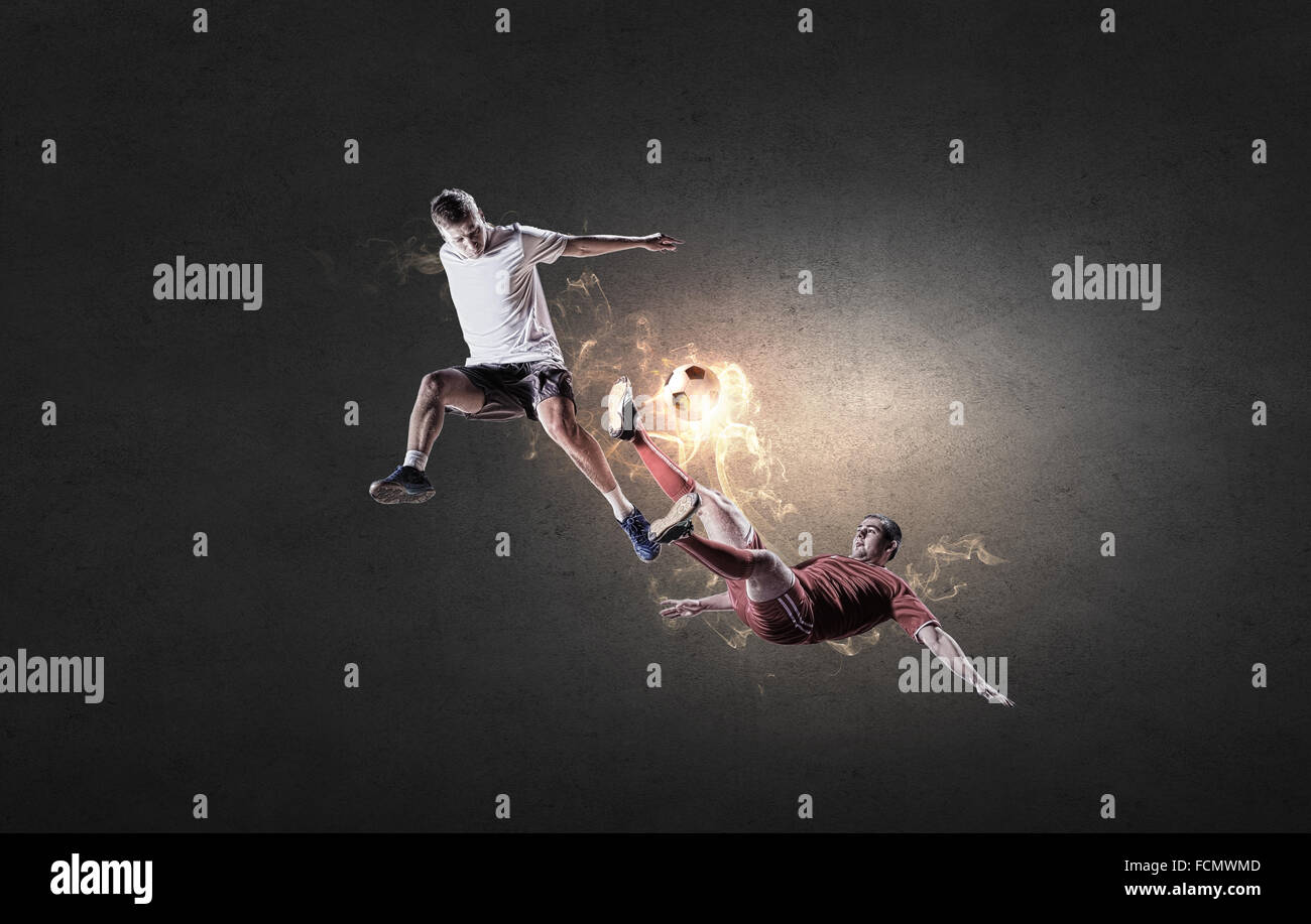 Two football players in jump fighting for ball Stock Photo - Alamy