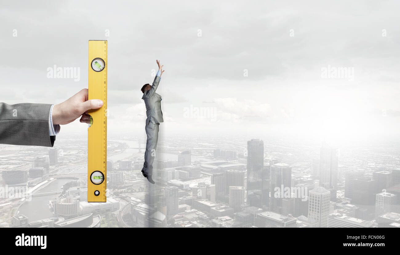 Hand measuring businessman jumping high in sky Stock Photo - Alamy