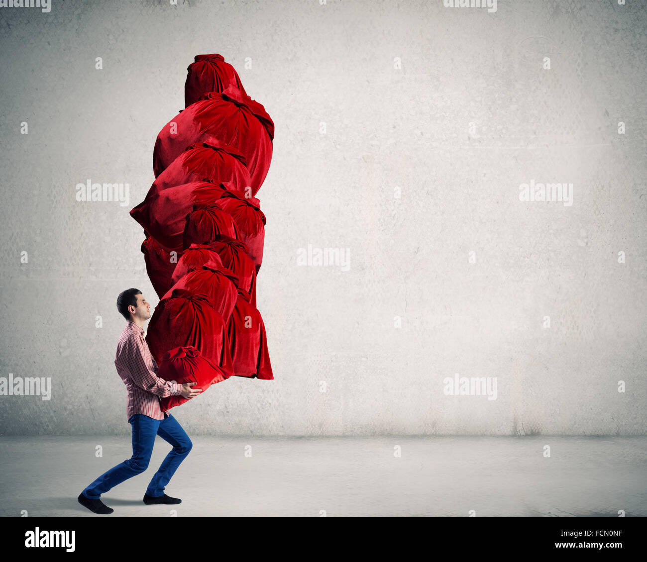 Young man in casual carrying heavy red bag Stock Photo - Alamy