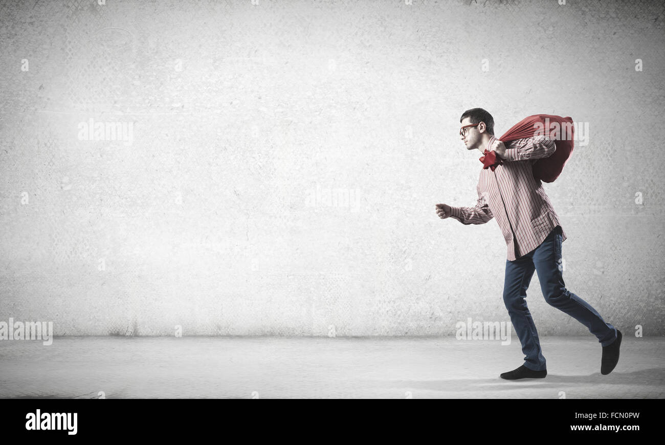 Young man in casual carrying heavy red bag Stock Photo - Alamy