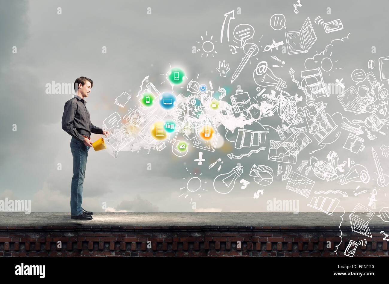 Young man in casual splashing icons from bucket Stock Photo - Alamy