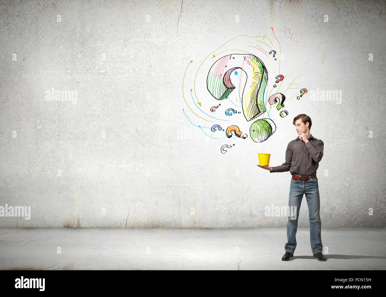 Young man in casual and question marks from bucket Stock Photo - Alamy