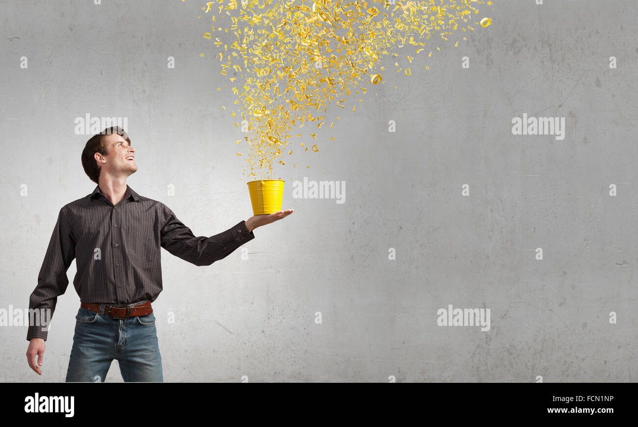 Young man in casual splashing paint from bucket Stock Photo - Alamy