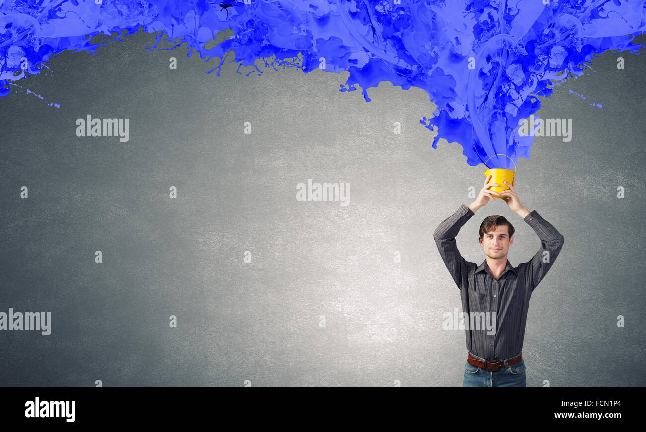 Young man in casual splashing paint from bucket Stock Photo - Alamy