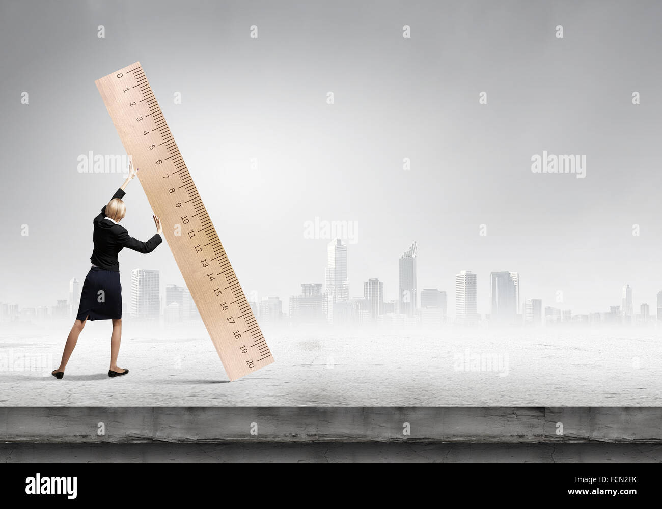 Young businesswoman measuring something with big ruler Stock Photo - Alamy