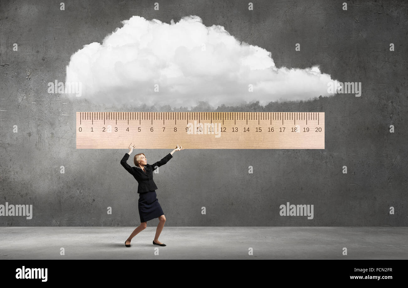 Young businesswoman measuring something with big ruler Stock Photo - Alamy