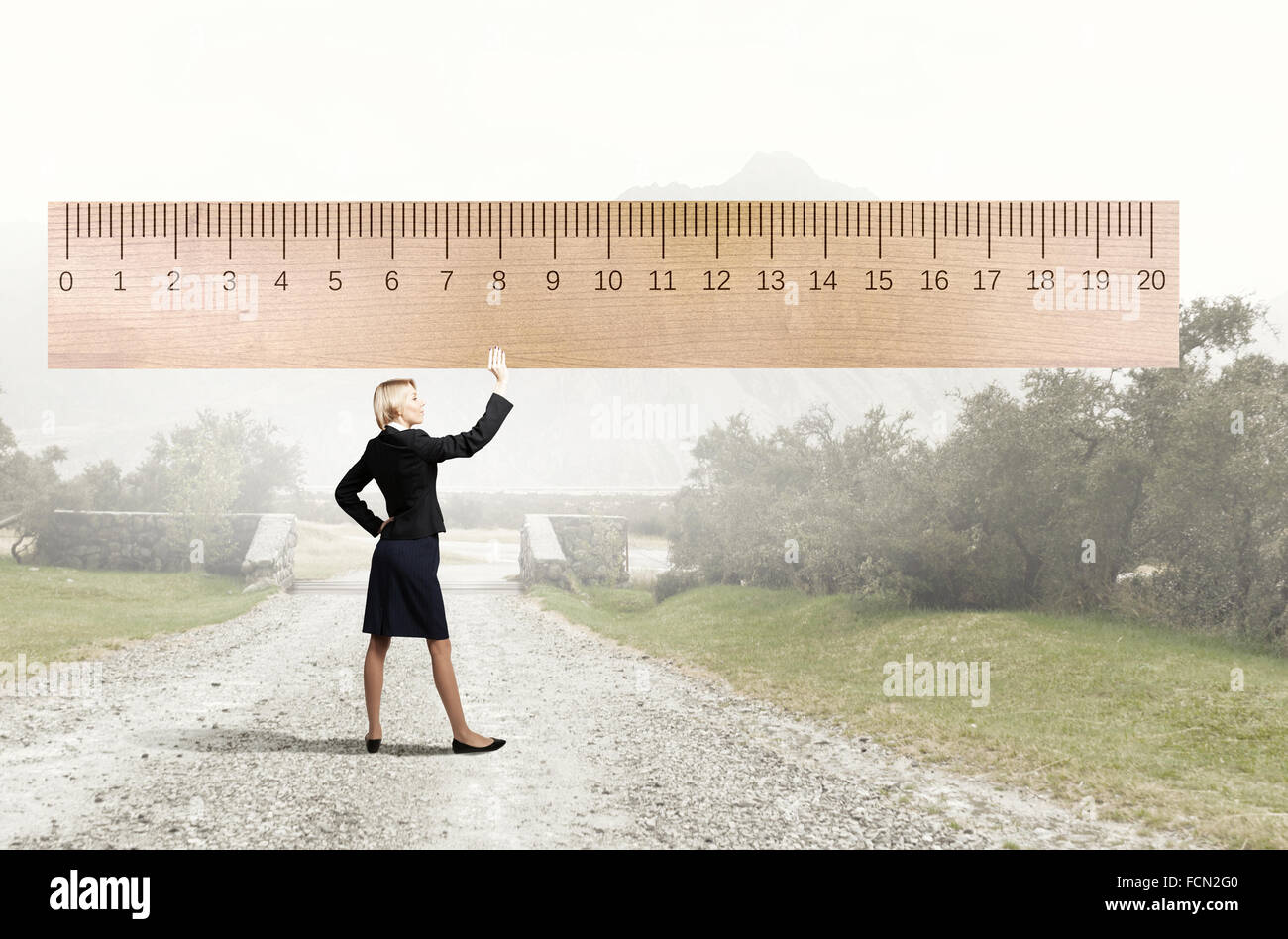 Young businesswoman measuring something with big ruler Stock Photo - Alamy