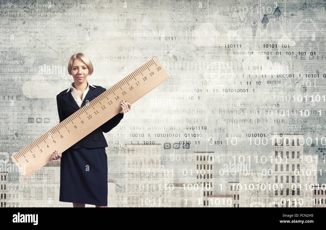 Young businesswoman measuring something with big ruler Stock Photo - Alamy