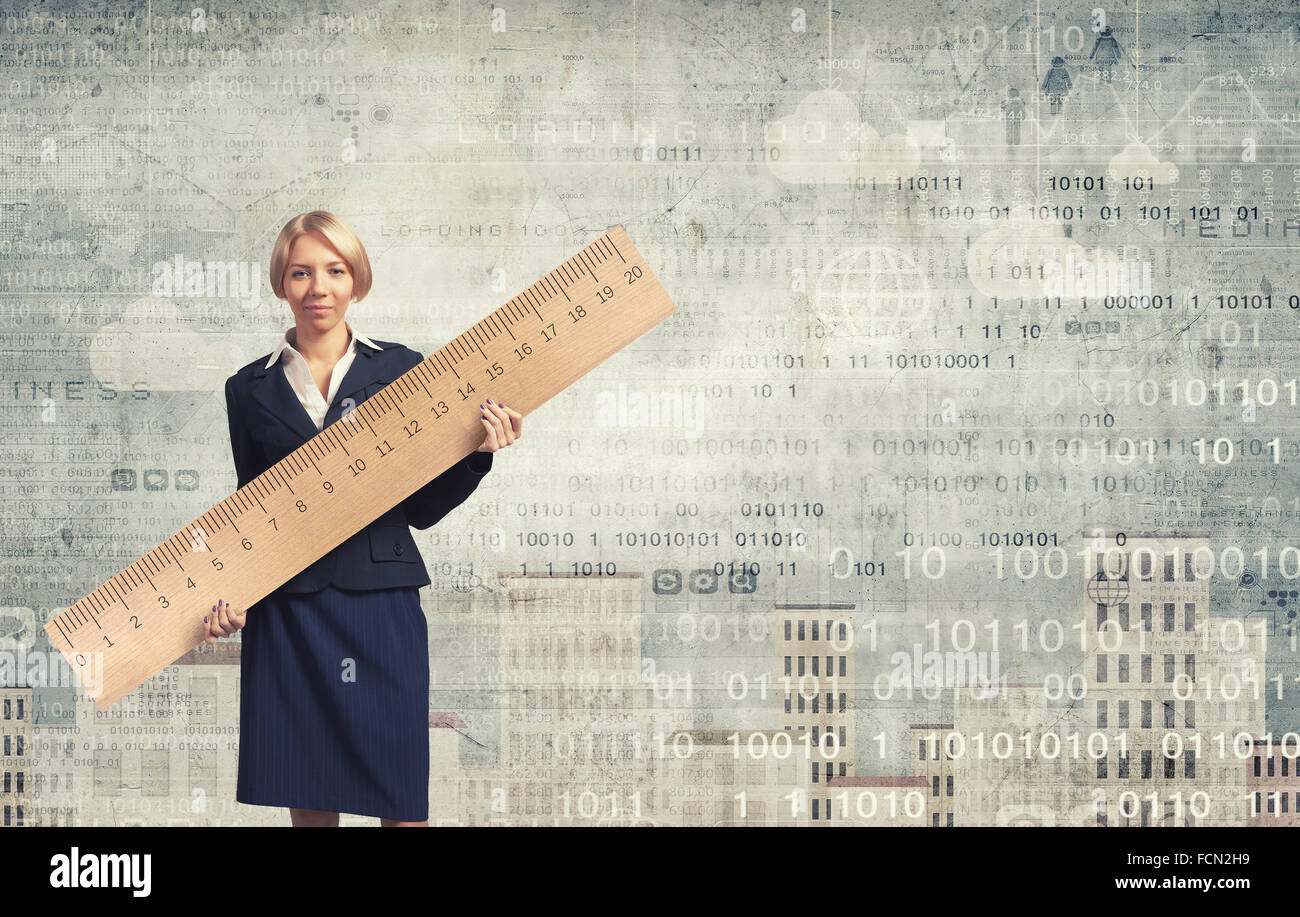 Young businesswoman measuring something with big ruler Stock Photo - Alamy