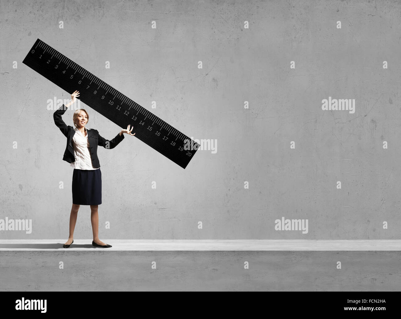 Young businesswoman measuring something with big ruler Stock Photo - Alamy