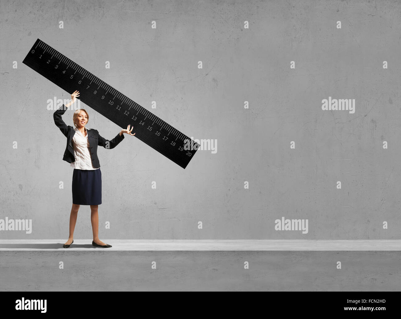 Young businesswoman measuring something with big ruler Stock Photo - Alamy
