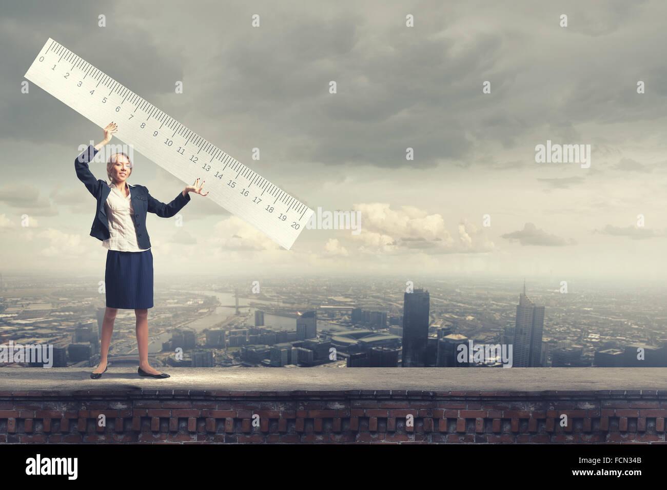 Young businesswoman measuring something with big ruler Stock Photo - Alamy