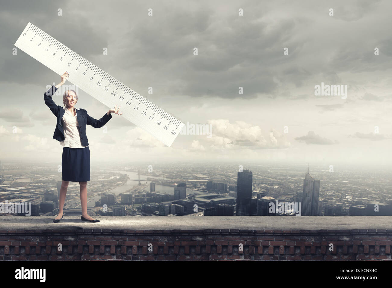 Young businesswoman measuring something with big ruler Stock Photo - Alamy
