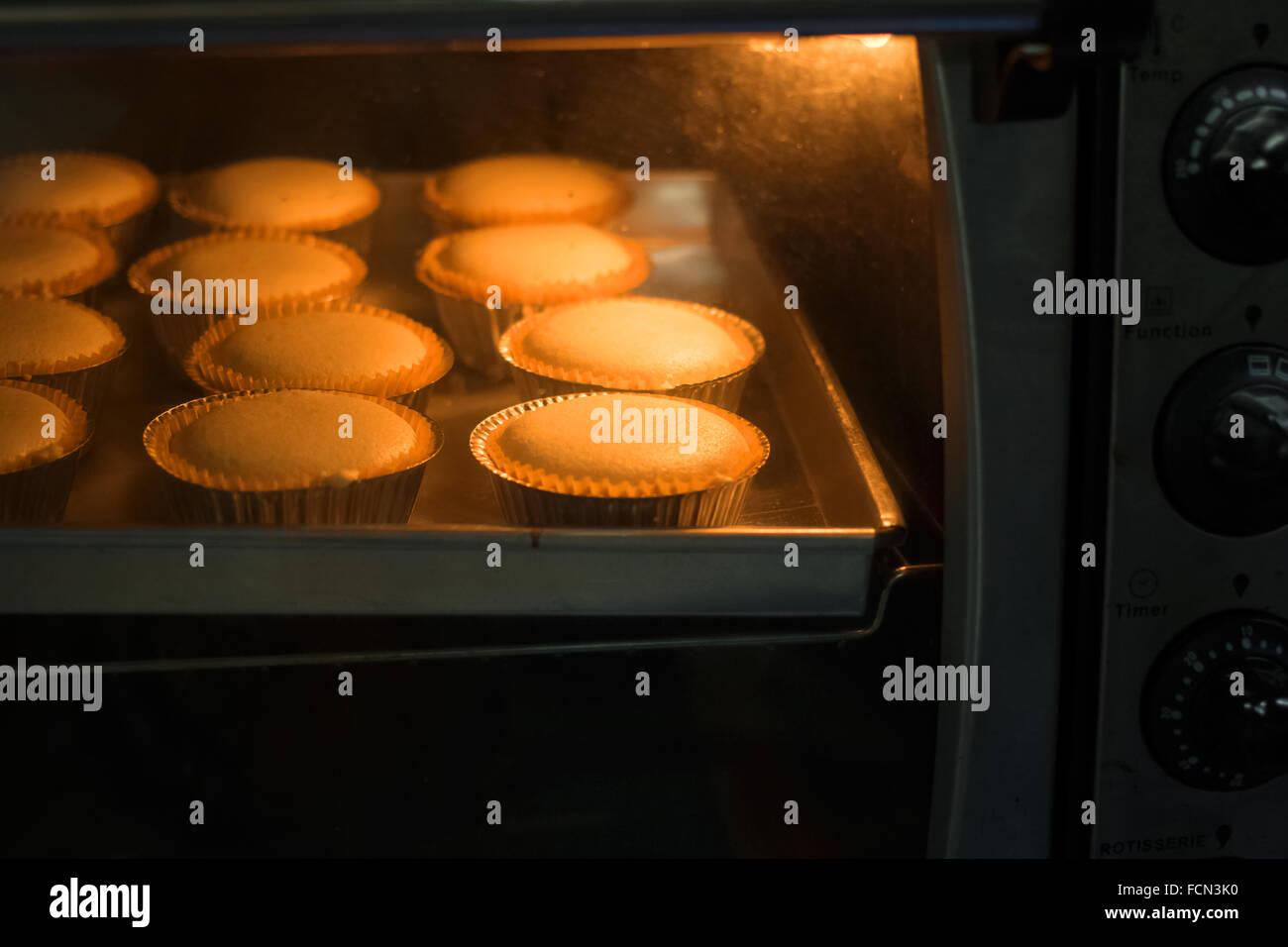 Baked cup cakes on a tray in the oven Stock Photo - Alamy
