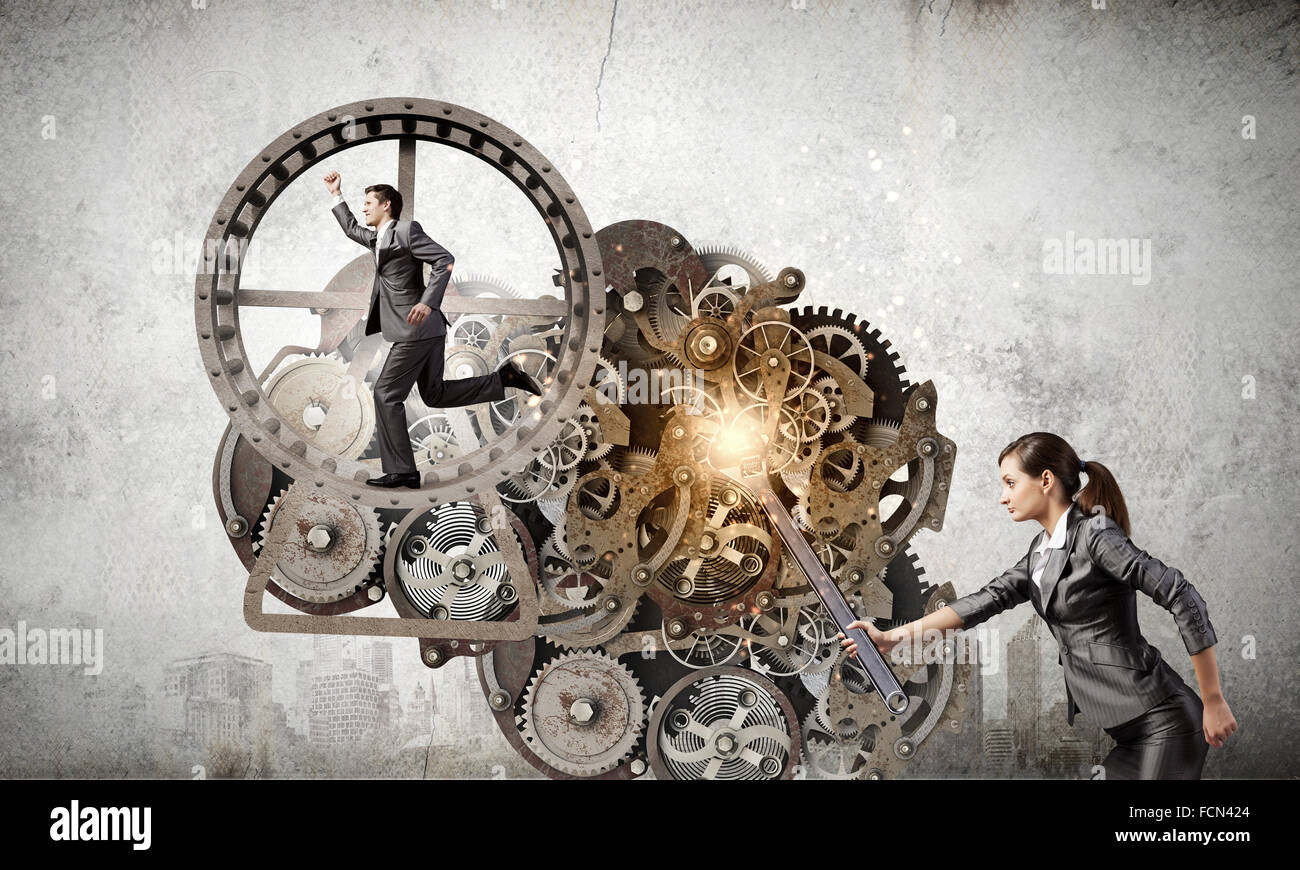 Young businesswoman fixing gears mechanism with wrench Stock Photo - Alamy