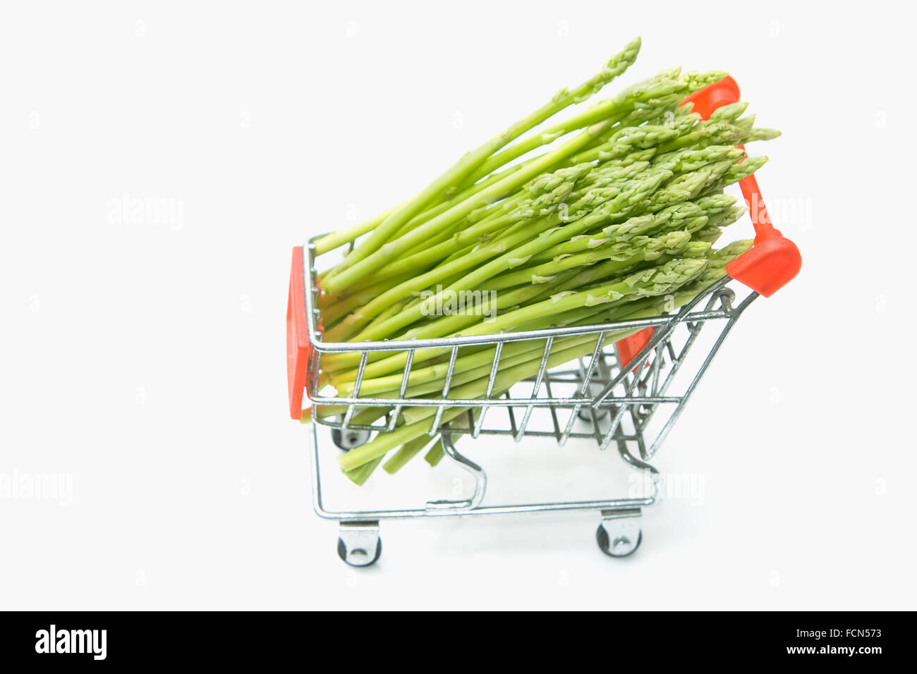 Fresh green asparagus in shopping cart on white background Stock Photo ...