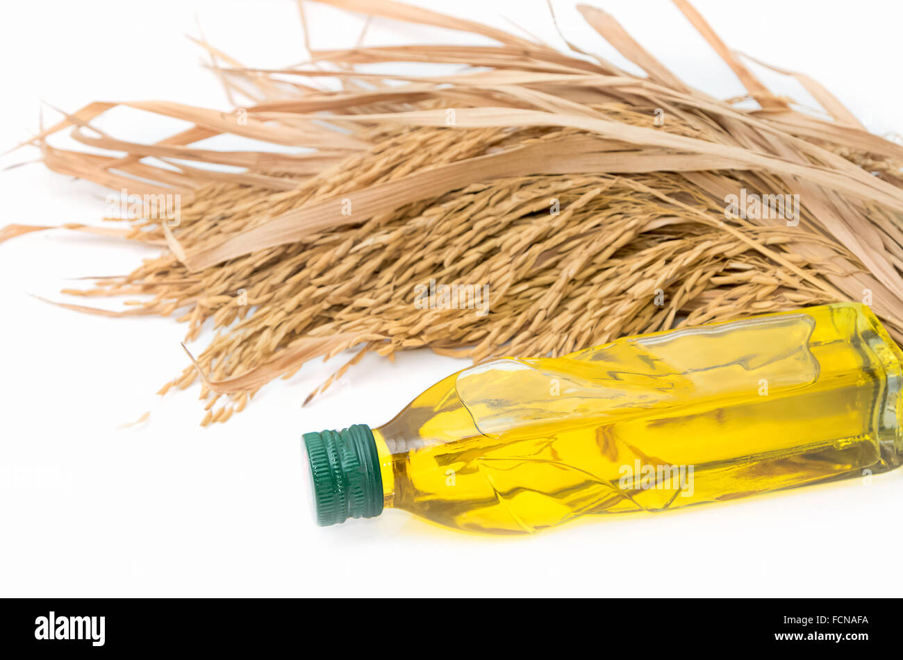 Rice bran oil in bottle glass with rice paddy on white Stock Photo - Alamy