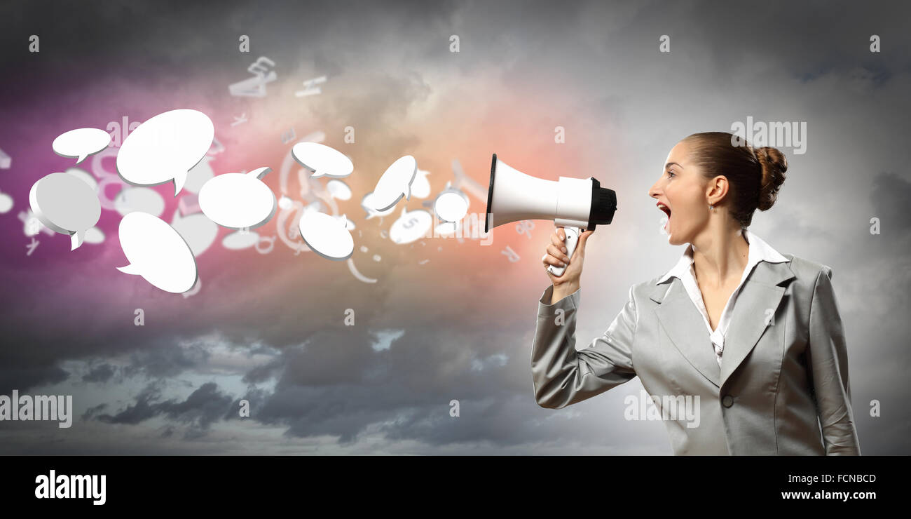businesswoman in grey suit screaming into megaphone Stock Photo - Alamy