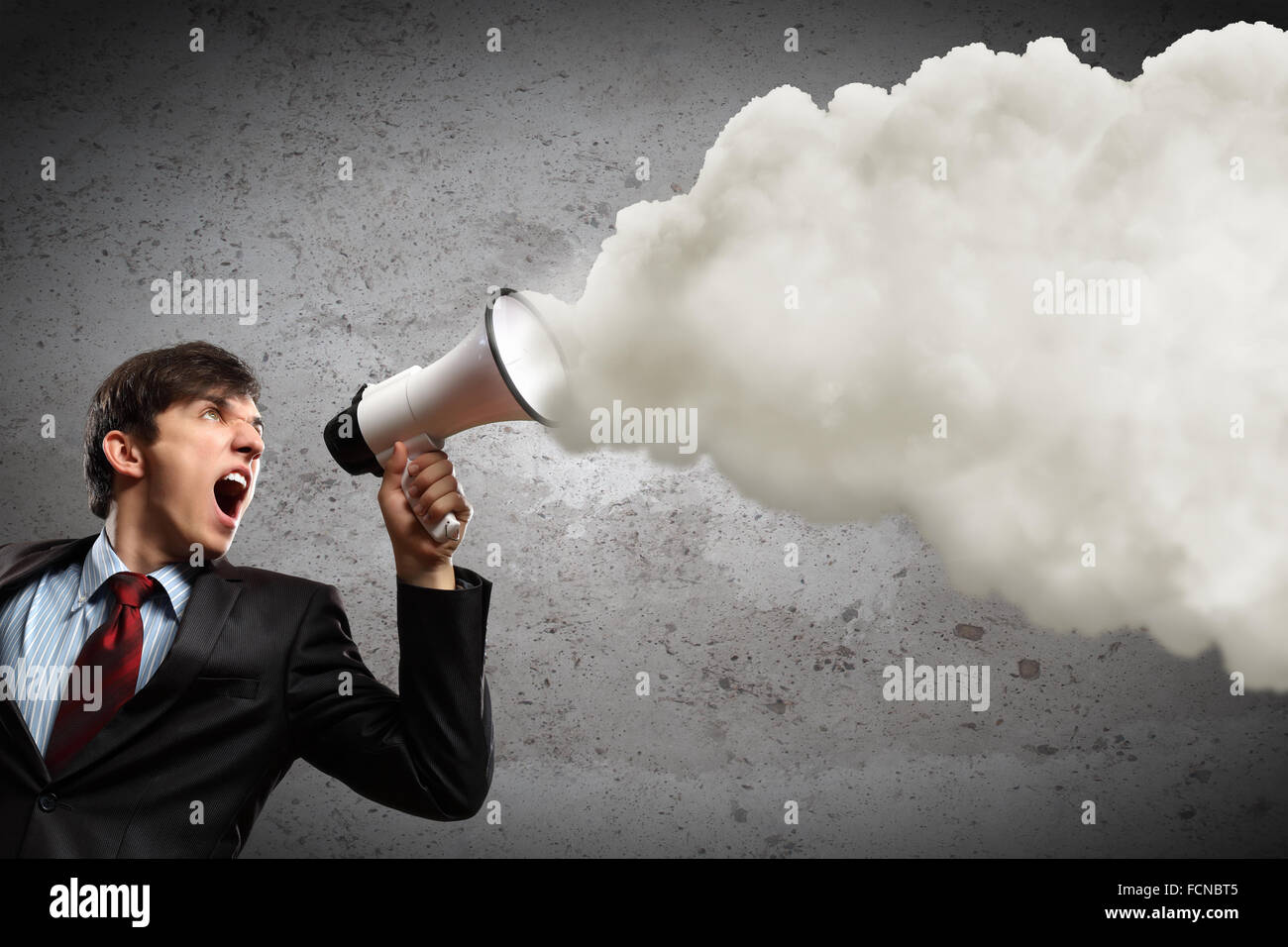 young businessman in black suit screaming into megaphone Stock Photo ...
