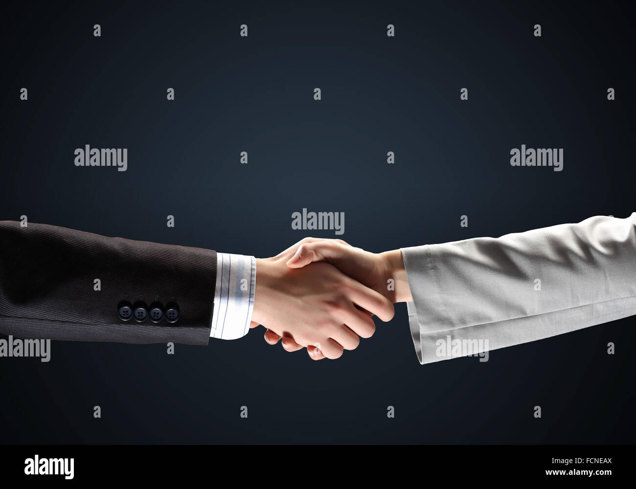 image of business handshake against black background Stock Photo - Alamy