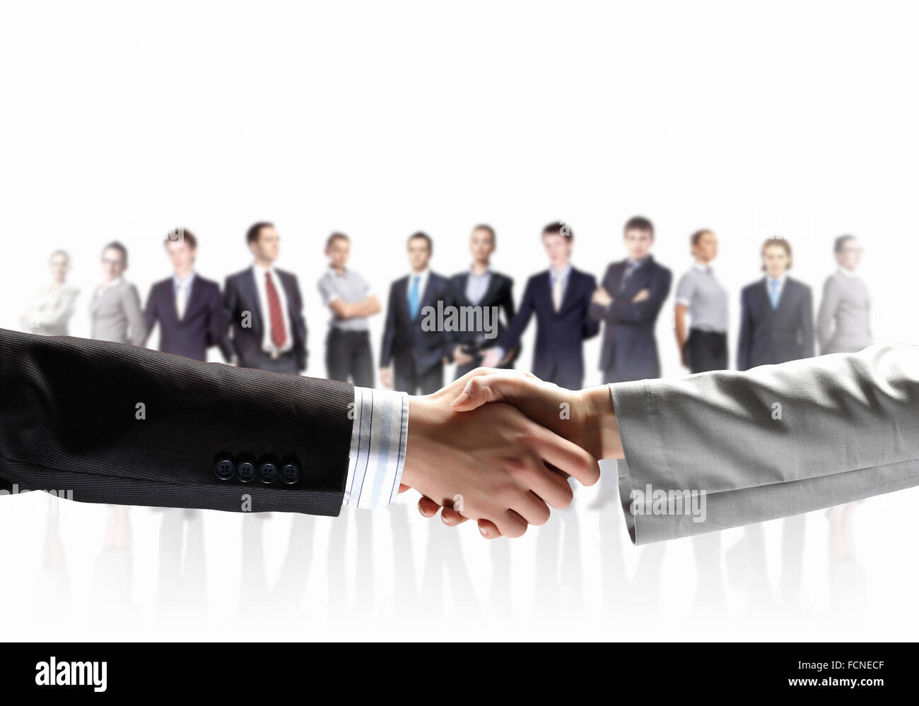 business handshake against white background and standing businesspeople ...