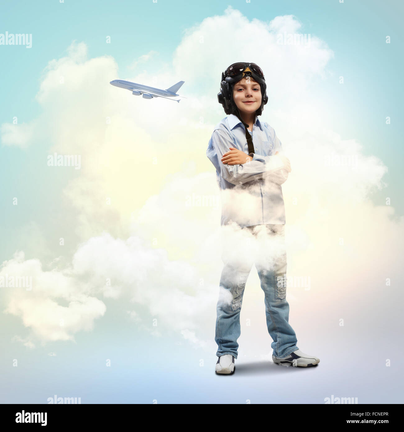 Image of little boy in pilots helmet with flying airplane in background ...