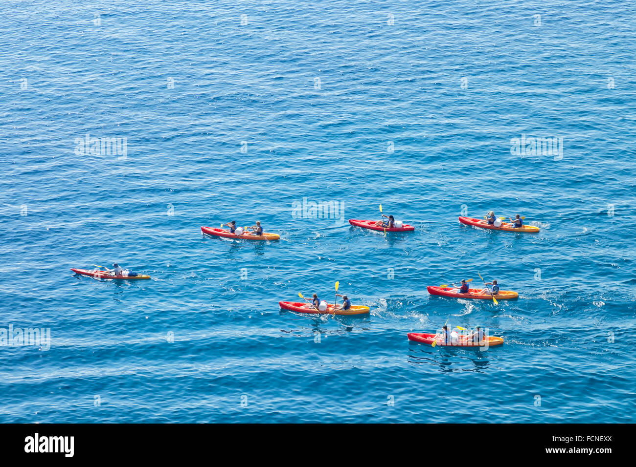 Aerial view of people in red orange kayaks paddling in the middle of ...